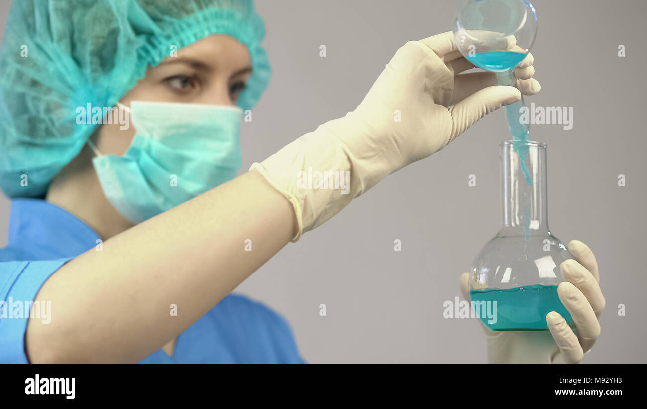 Researcher making experiment in laboratory mixing two liquid, medicine ...