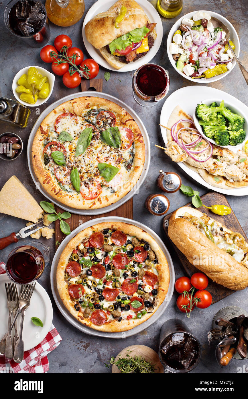 Big dinner with pizza, salad and sandwiches overhead view Stock Photo ...