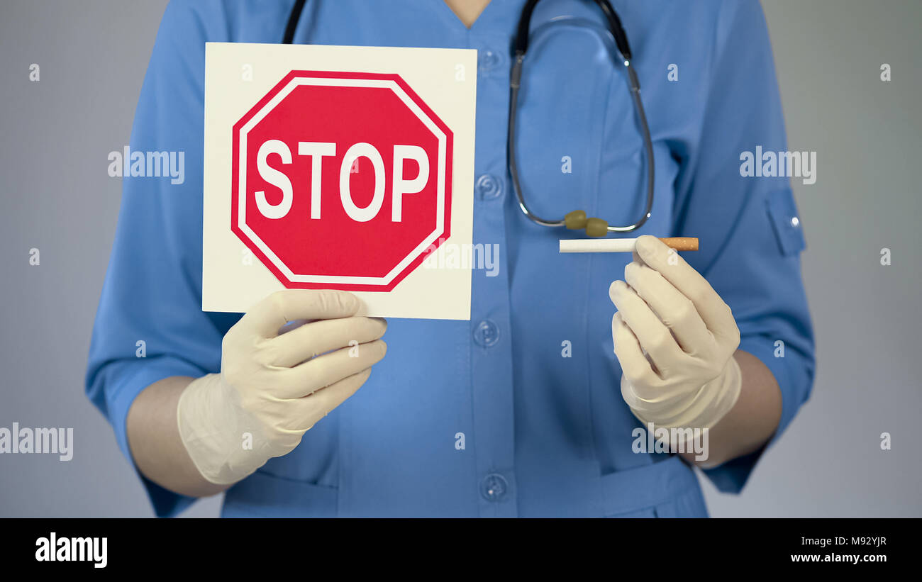 Hospital nurse holding stop sign and cigarette, preventing unhealthy ...