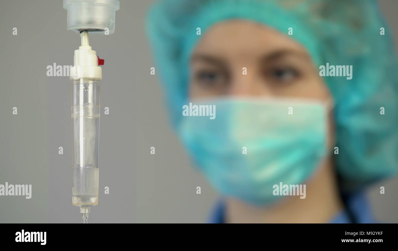 Nurse anesthetist checking drop counter, taking care of patient after ...