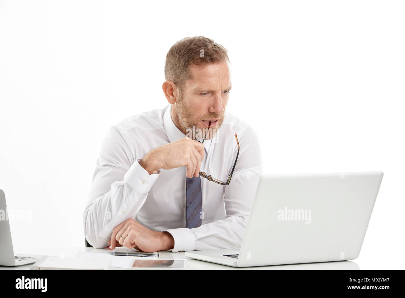 Stressed middle aged businessman sitting at office desk and working on ...