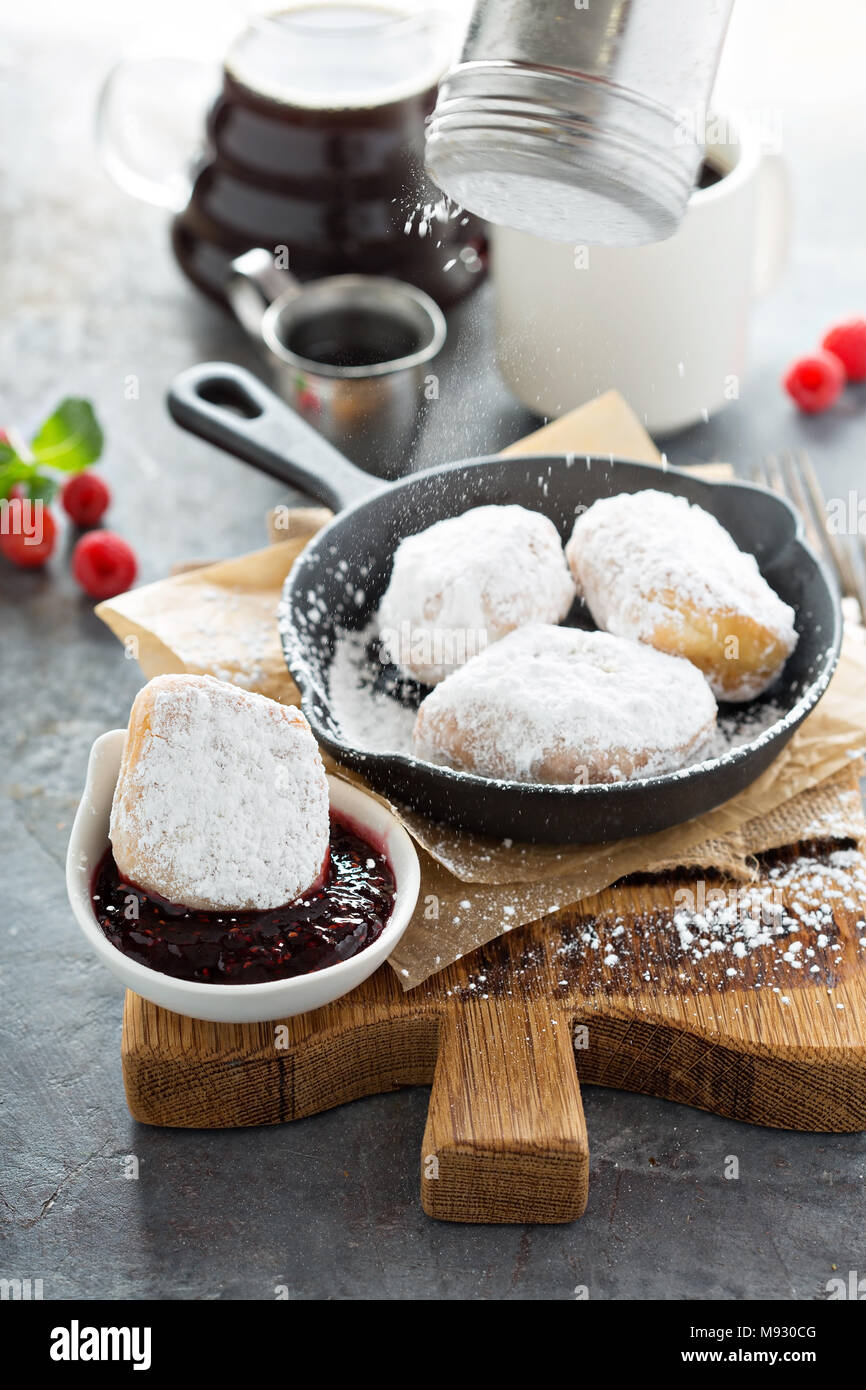 Beignets with powdered sugar pouring over and raspberry jam Stock Photo ...