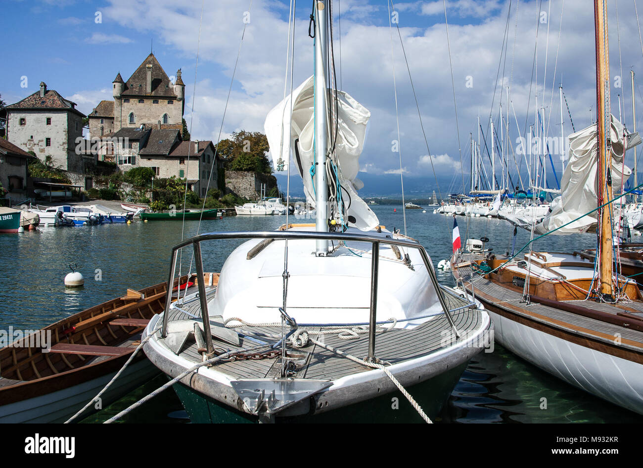 Sailing boats moored with their sails furled in a pretty lakeside ...