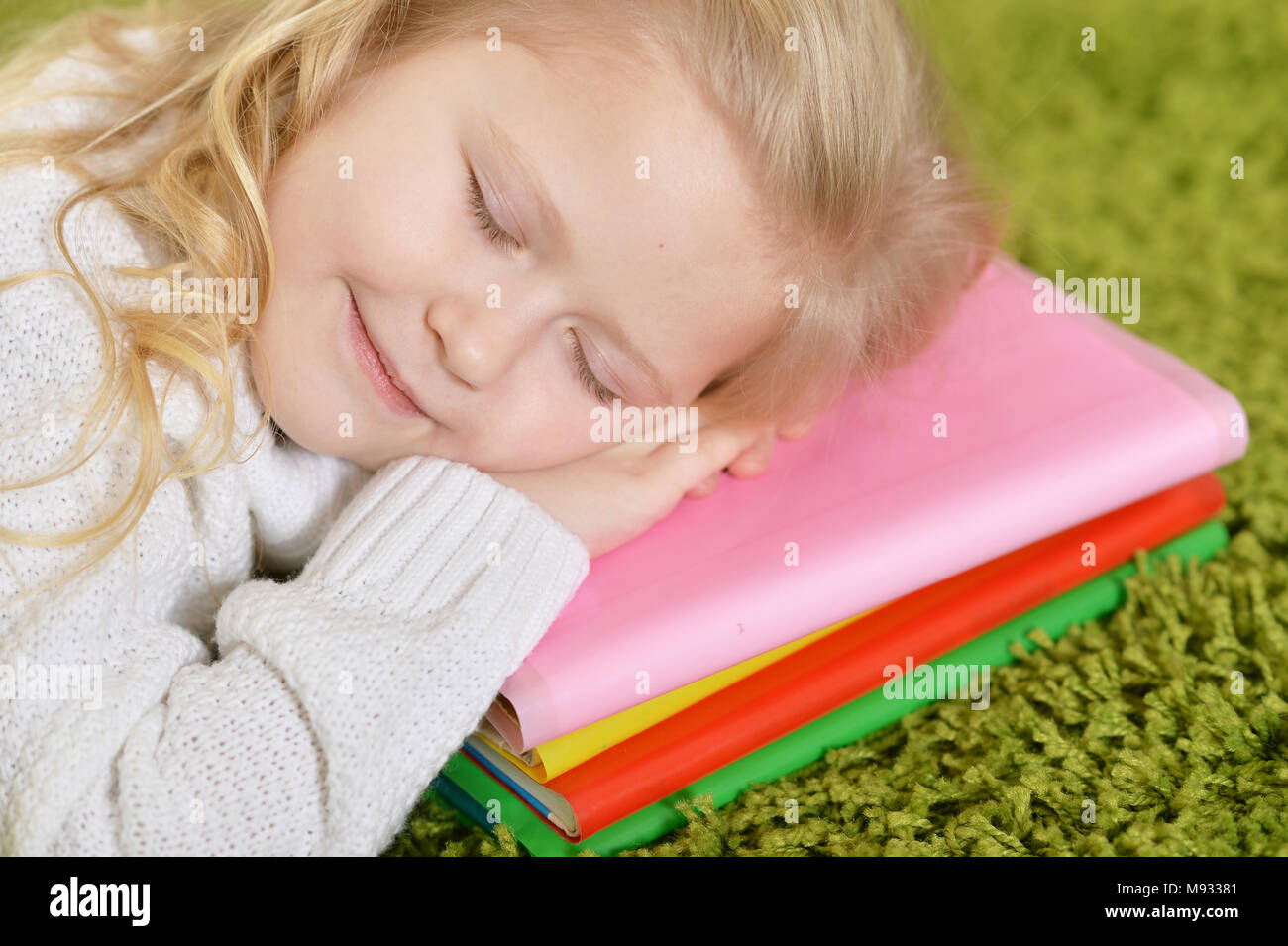 Portrait of cute little girl falling asleep on books Stock Photo - Alamy