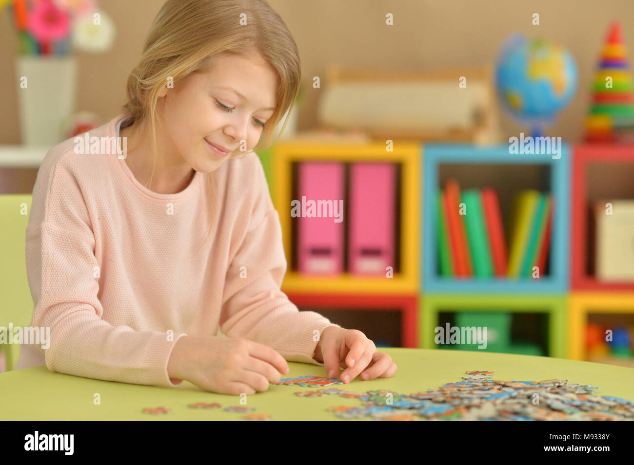 Portrait of cute little girl collecting puzzles Stock Photo - Alamy