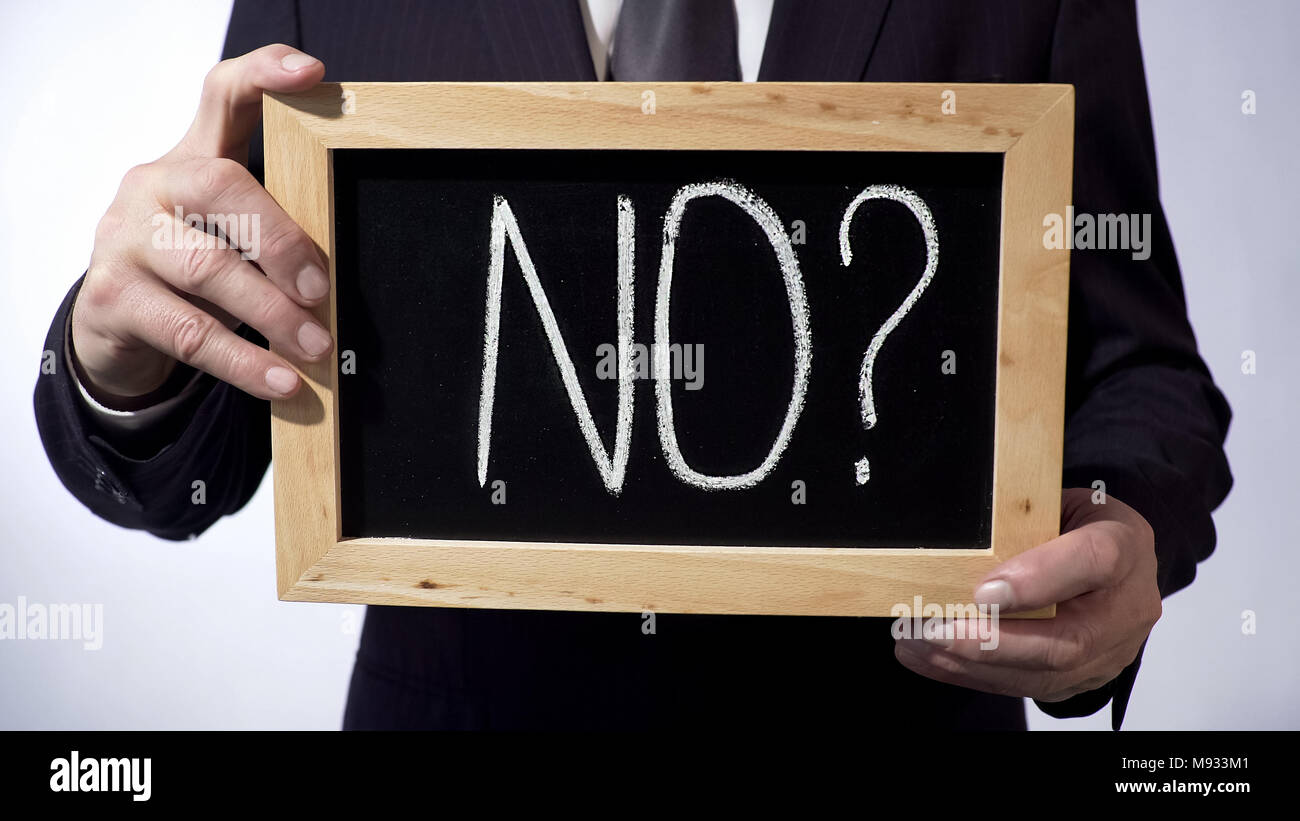 No with question mark written on blackboard, businessman holding sign ...