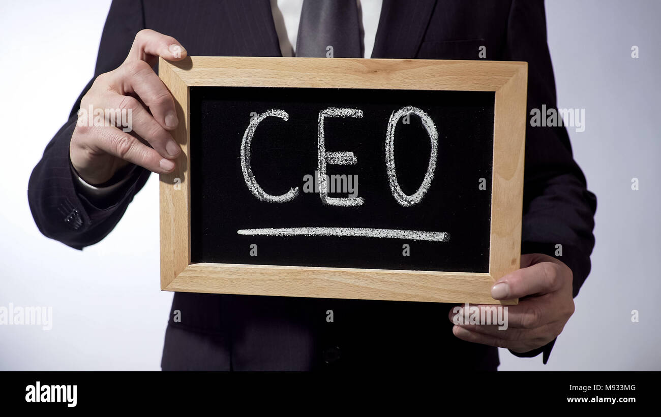 CEO written on blackboard, man in classic suit holding sign, business ...