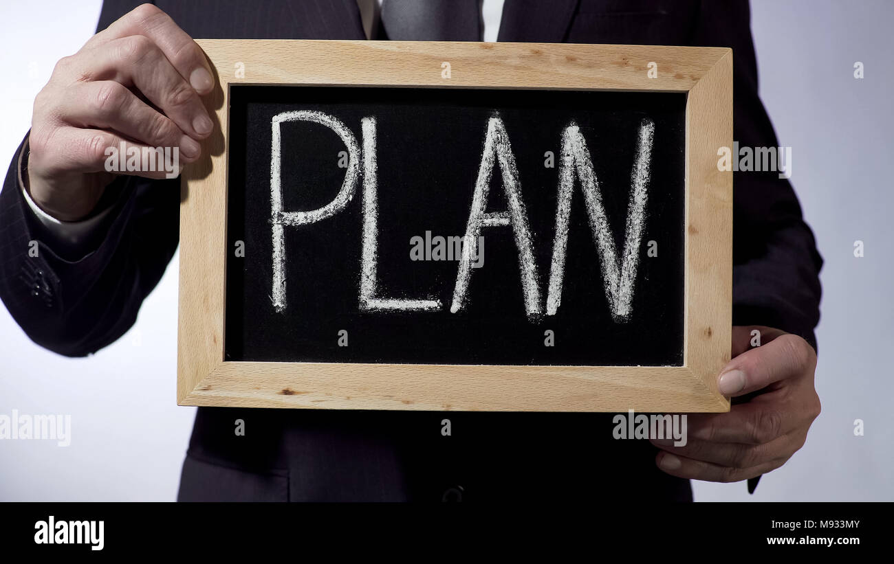 Plan written on blackboard, businessman holding sign, business concept ...