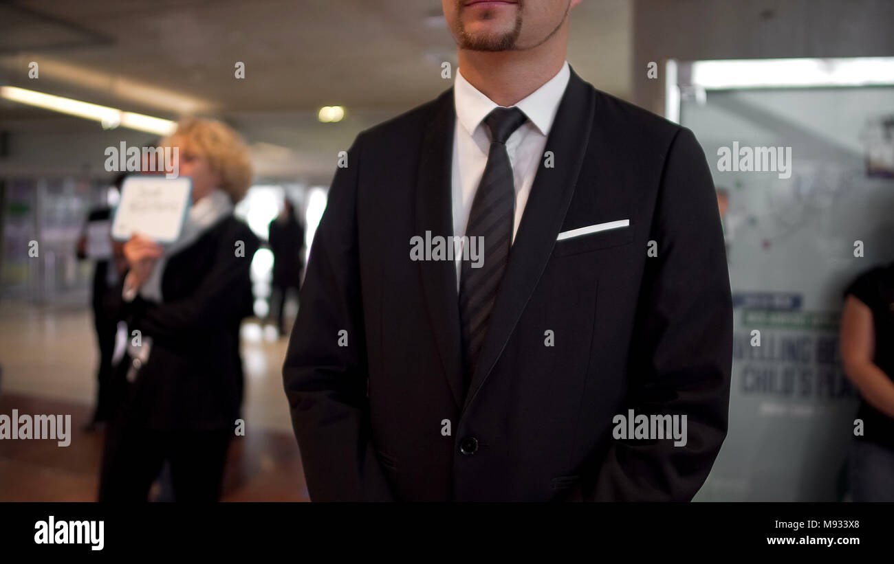 Travel agency representative waiting for arrivals in airport, tourism ...