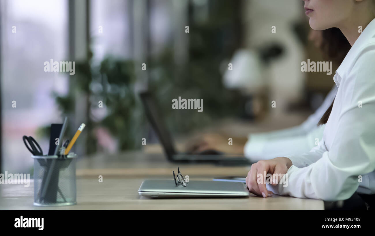 Woman folded hands on table, put glasses on laptop, tired eyes, blurred ...