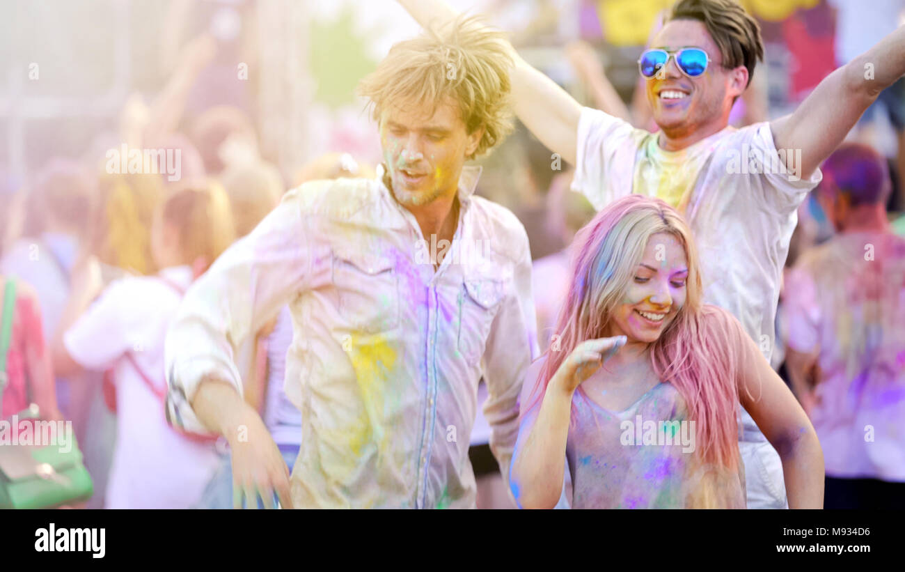 Happy friends dancing at color festival, having fun together, youth ...