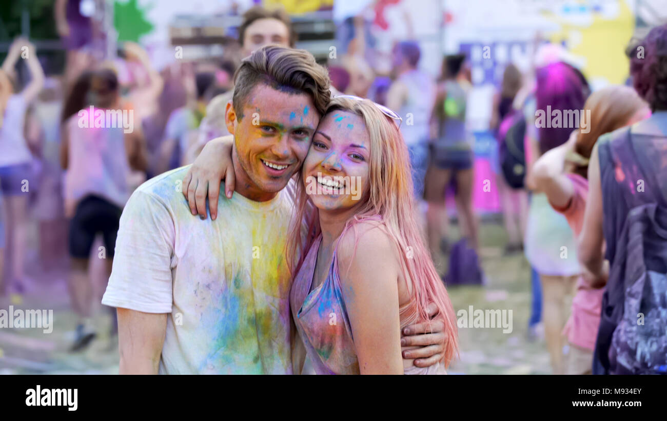Happy friends hanging out at festival, romantic couple hugging ...