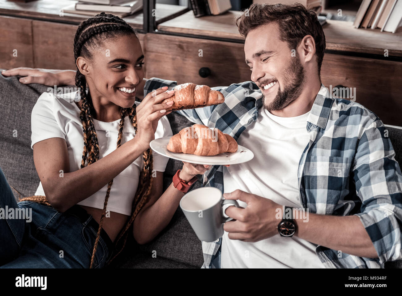 Cheerful positive woman feeding her boyfriend Stock Photo - Alamy