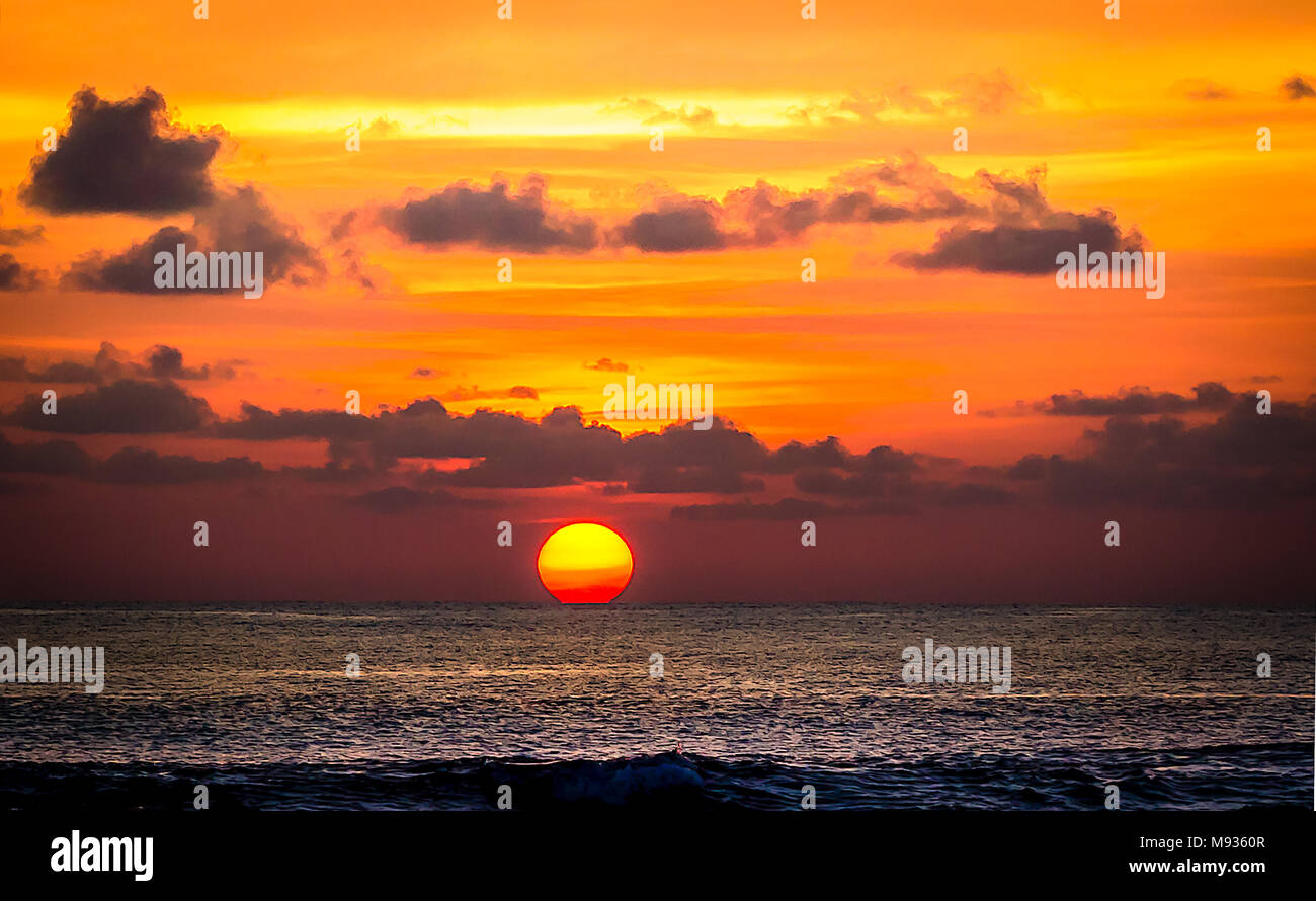 The sun setting in the equator Stock Photo - Alamy