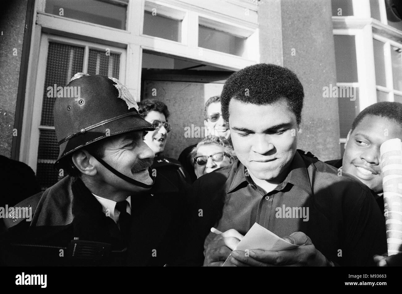 A policeman smiles at Muhammad Ali as he signs autographs in London ...