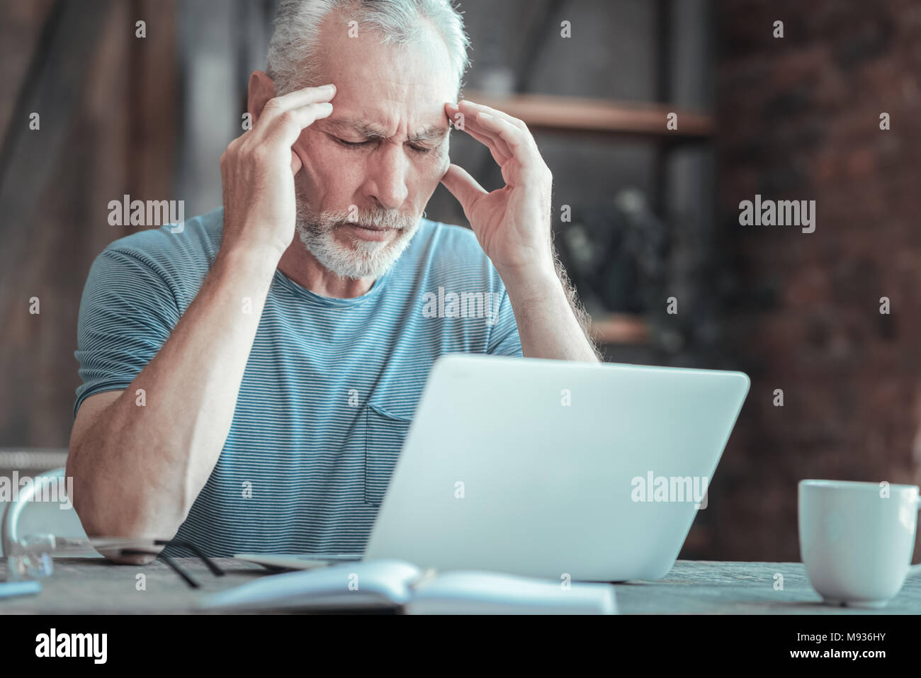 Serious sick man sitting and having head ache Stock Photo - Alamy