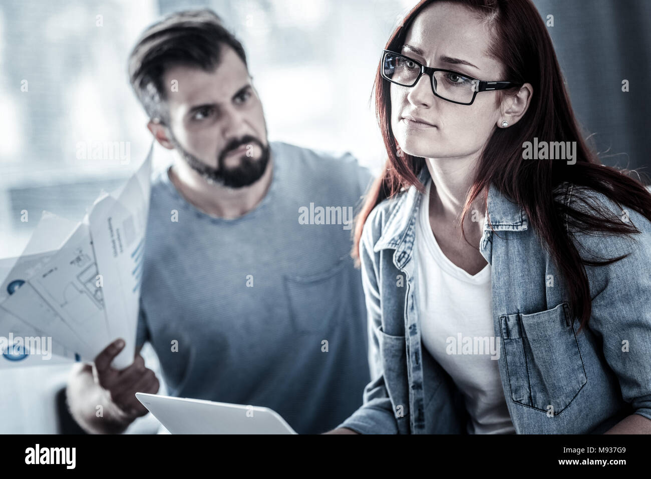 Thoughtful bespectacled woman sitting and looking aside Stock Photo - Alamy