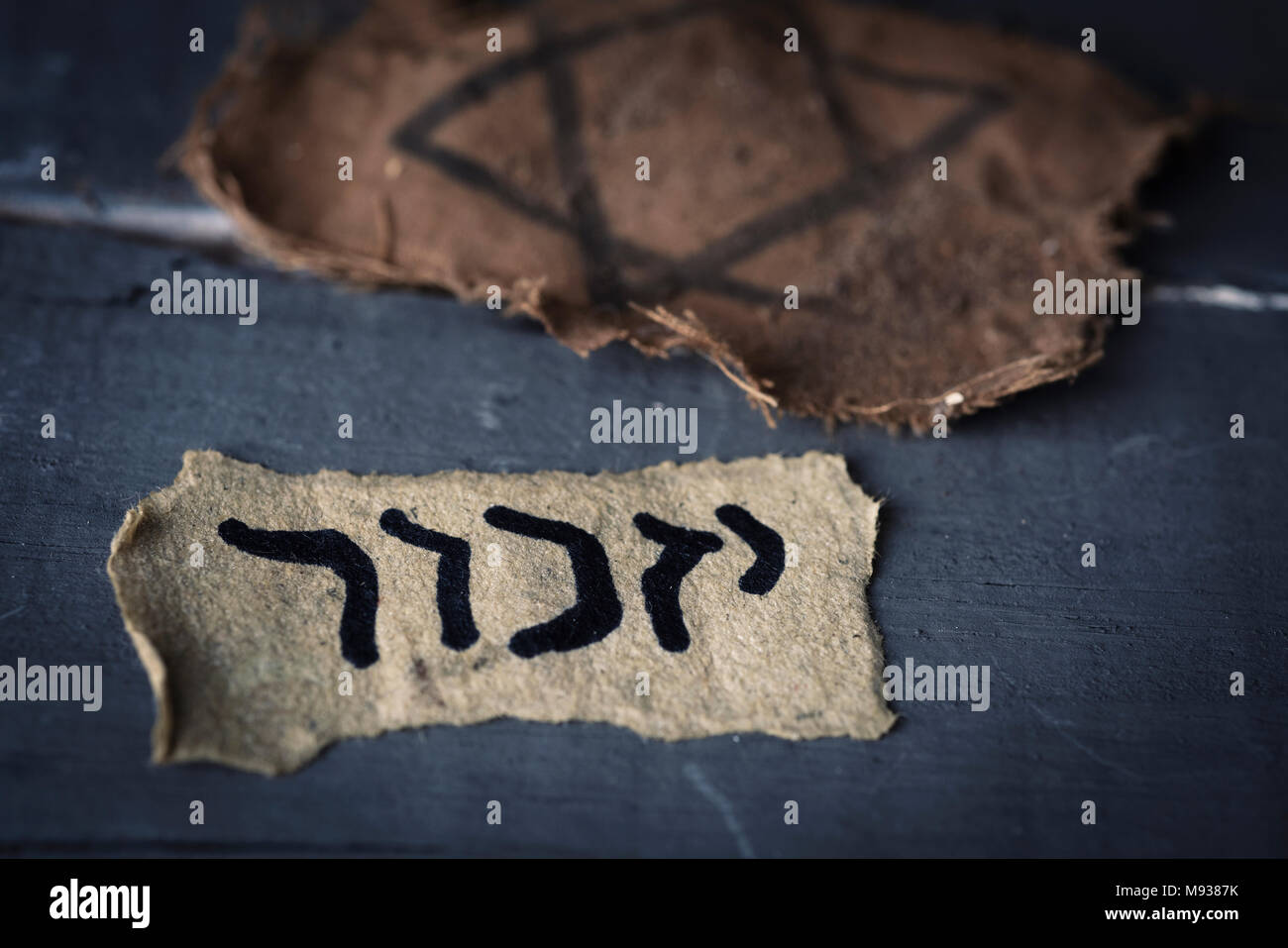 closeup of a ragged jewish badge and a yellowish piece of paper with ...