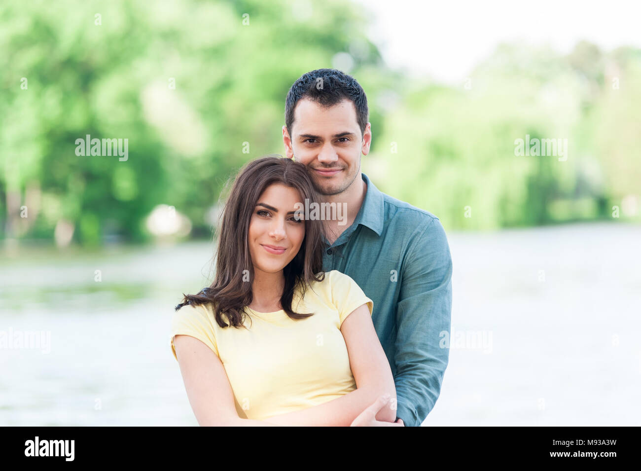Joyful and spontaneous couple in love, holding hands on a stone pier on ...