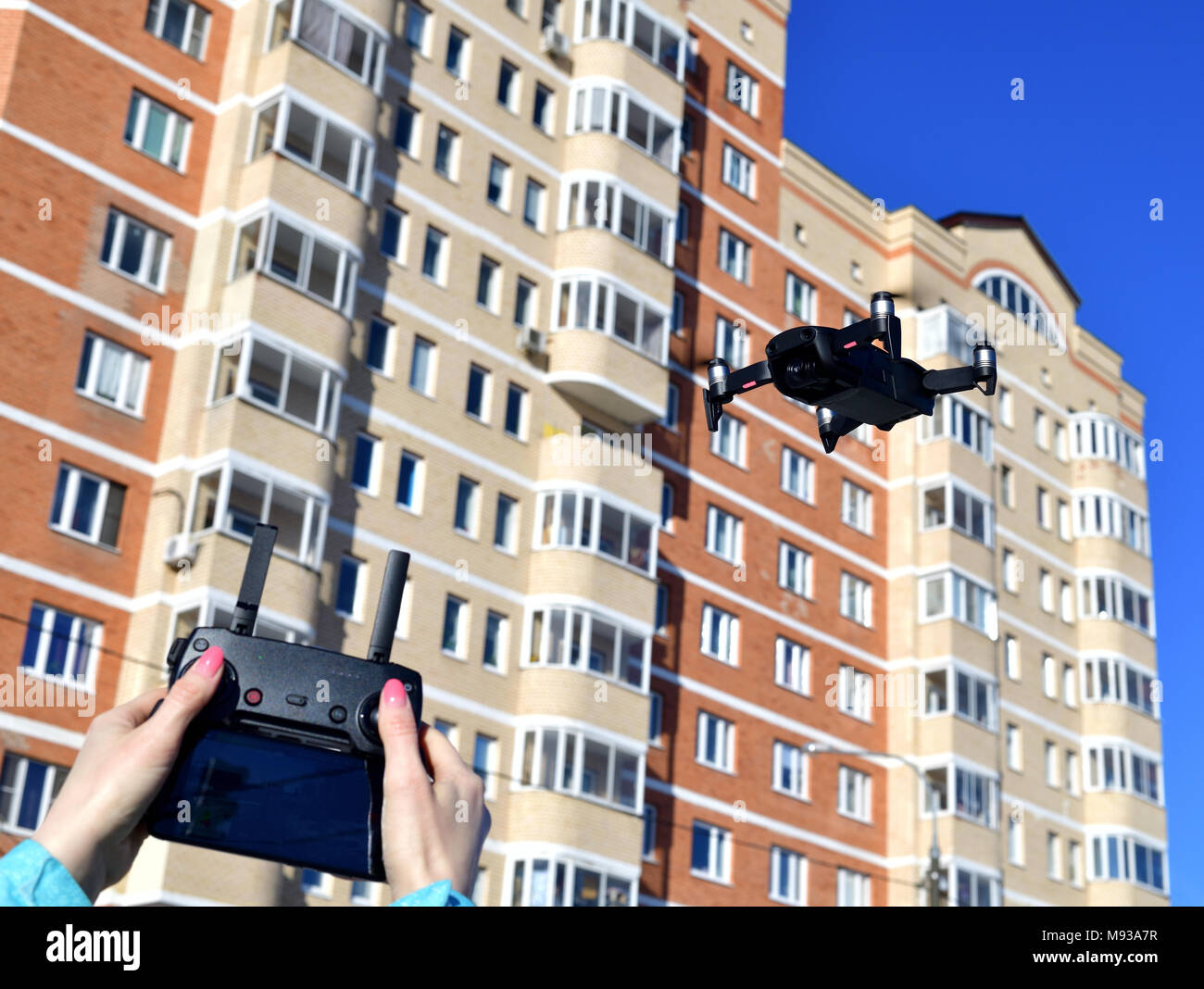 Quadrocopter flies in sky and hands with a control panel Stock Photo ...