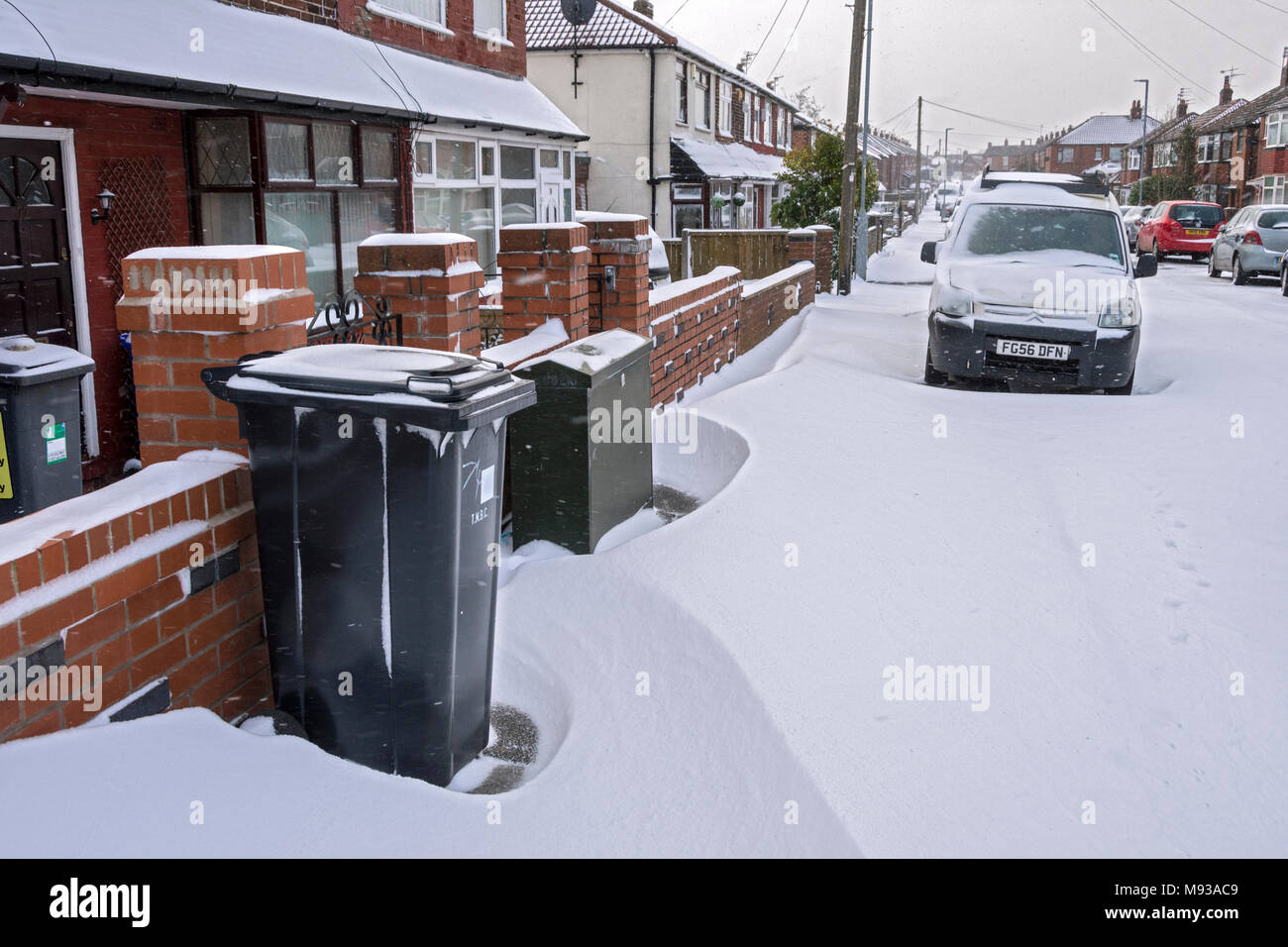 Wheelie bins and small snow drifts in a suburban street, Tameside ...