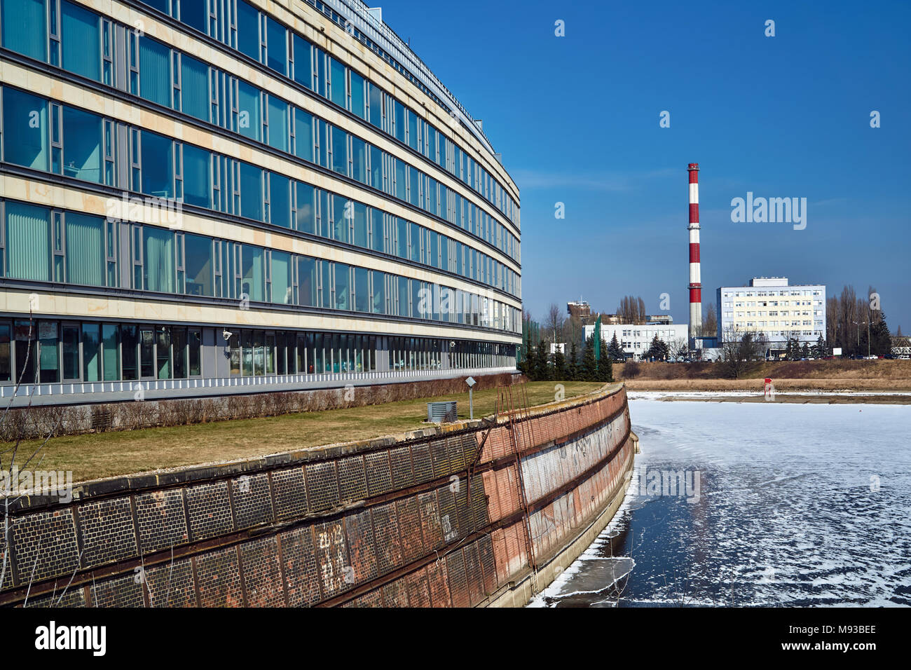 The facade of a modern building in the old river port and chimney power ...