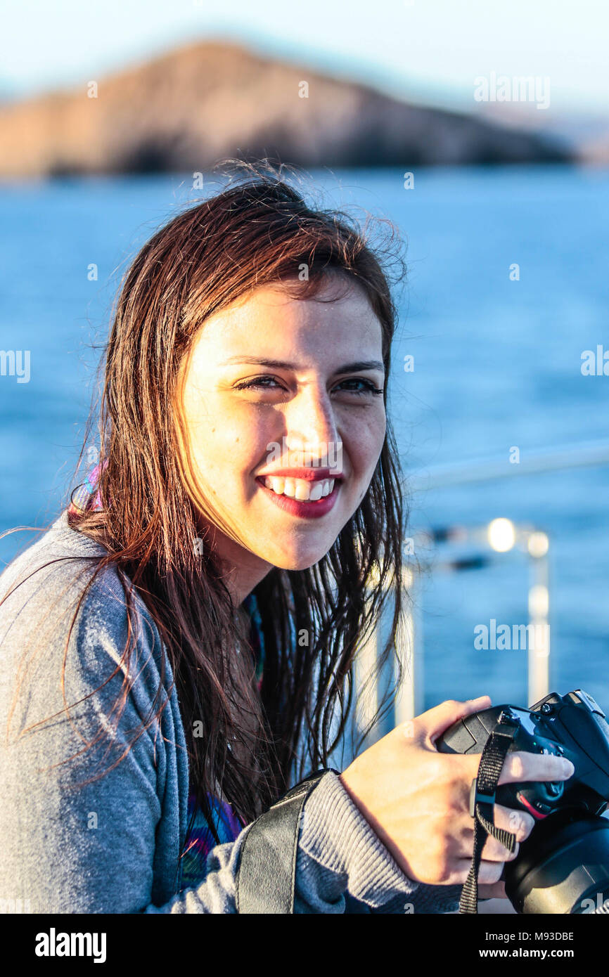 Teenage vacationers enjoy a sunny day, ride a yacht through the bay and ...