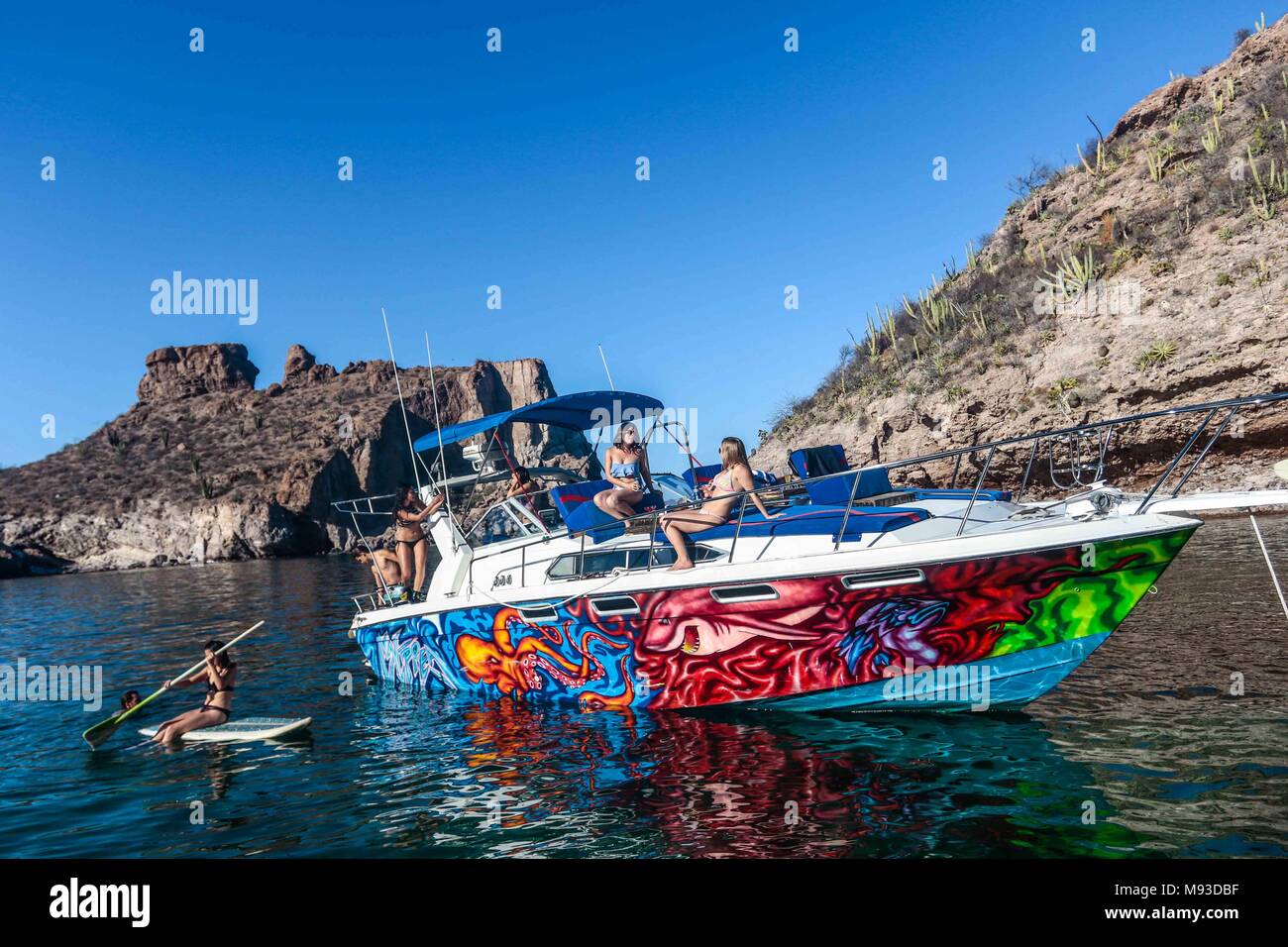 Teenage vacationers enjoy a sunny day, ride a yacht through the bay and ...