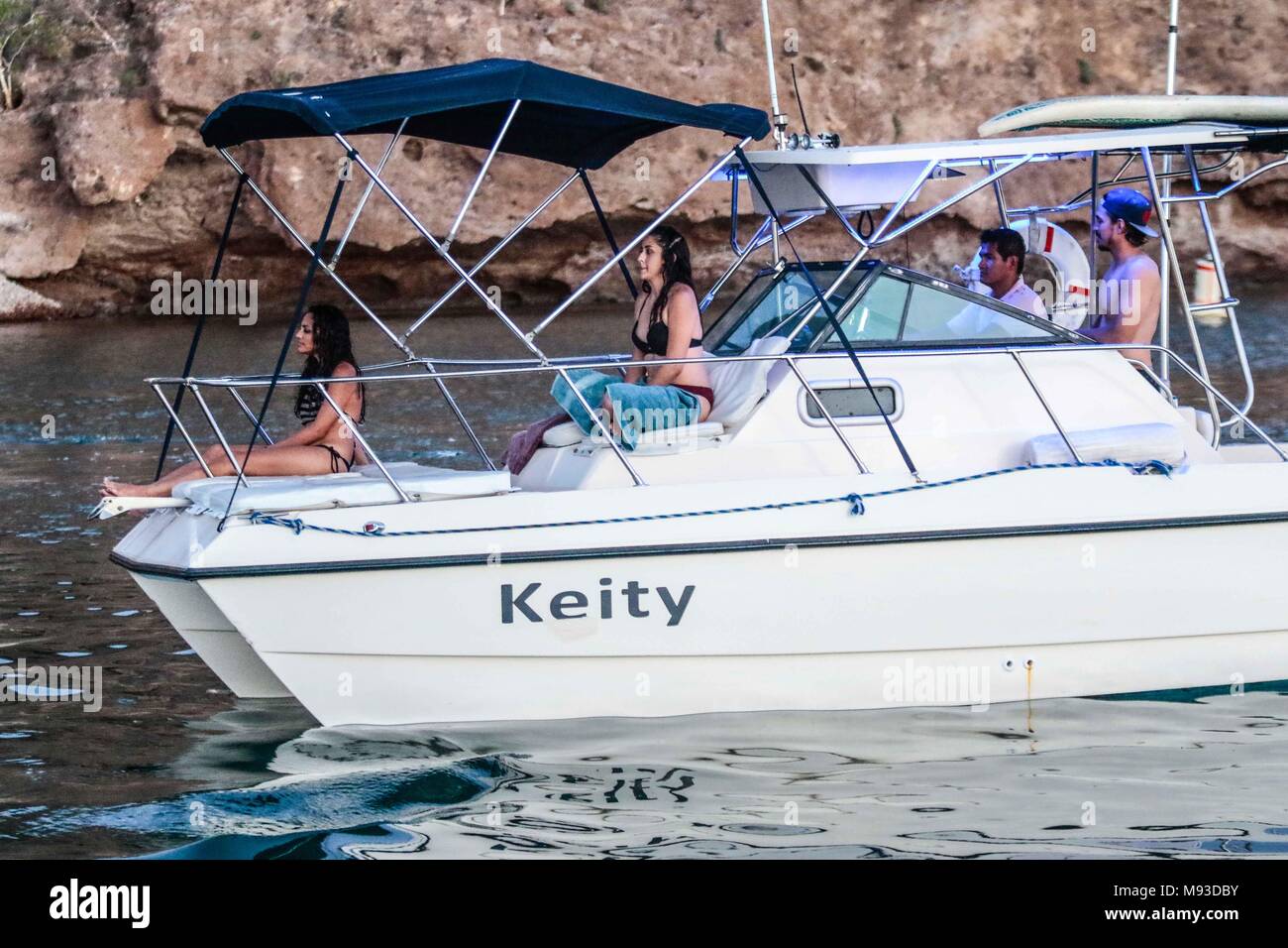 Teenage vacationers enjoy a sunny day, ride a yacht through the bay and ...