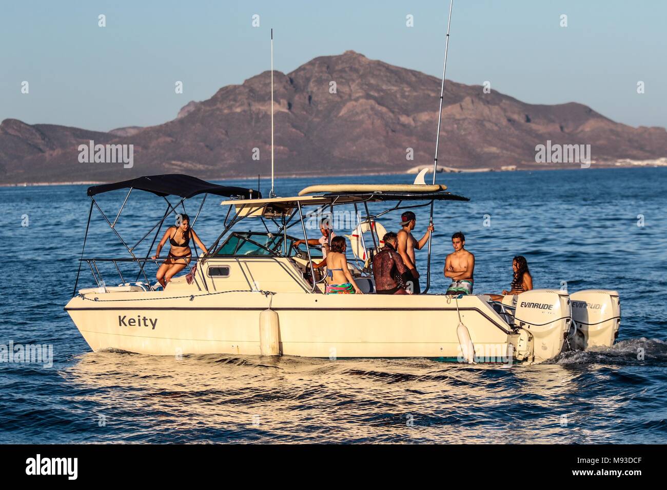 Teenage vacationers enjoy a sunny day, ride a yacht through the bay and ...