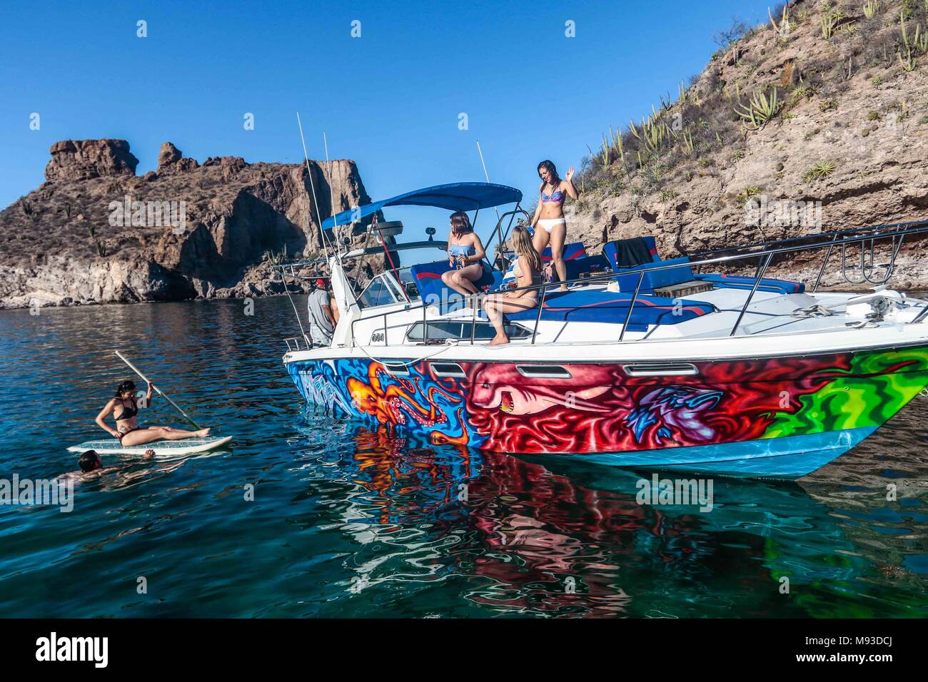 Teenage vacationers enjoy a sunny day, ride a yacht through the bay and ...