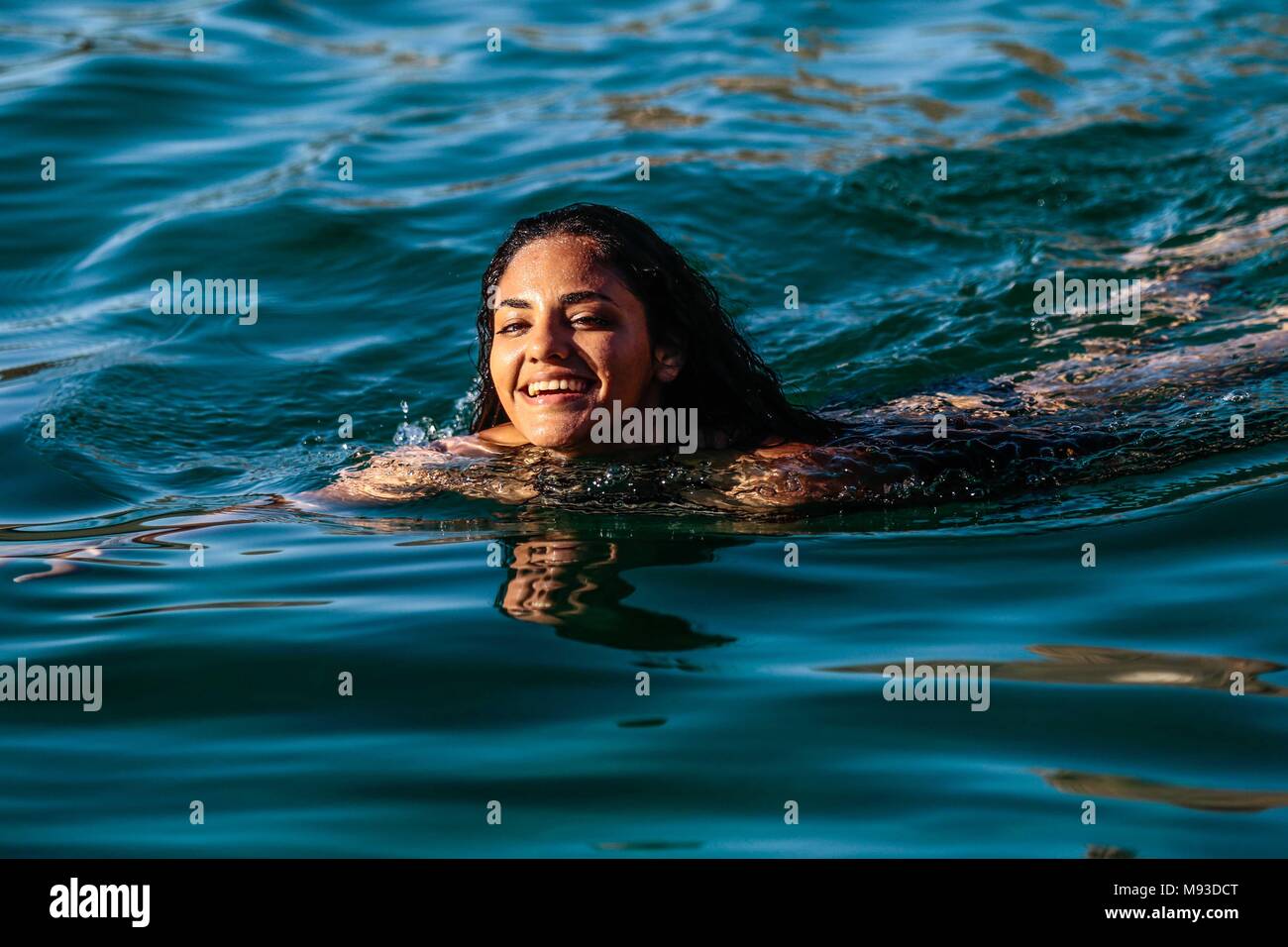 Teenage vacationers enjoy a sunny day, ride a yacht through the bay and ...