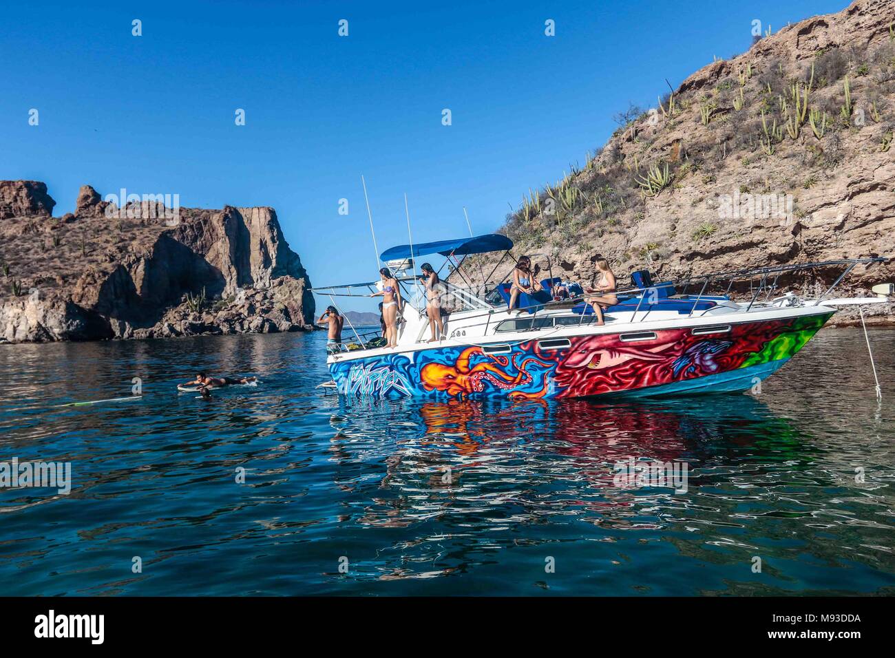 Teenage vacationers enjoy a sunny day, ride a yacht through the bay and ...