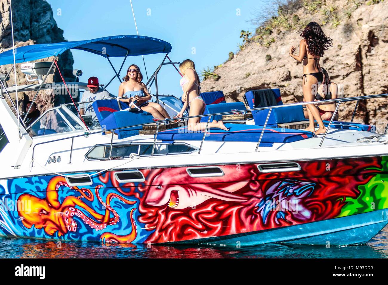 Teenage vacationers enjoy a sunny day, ride a yacht through the bay and ...