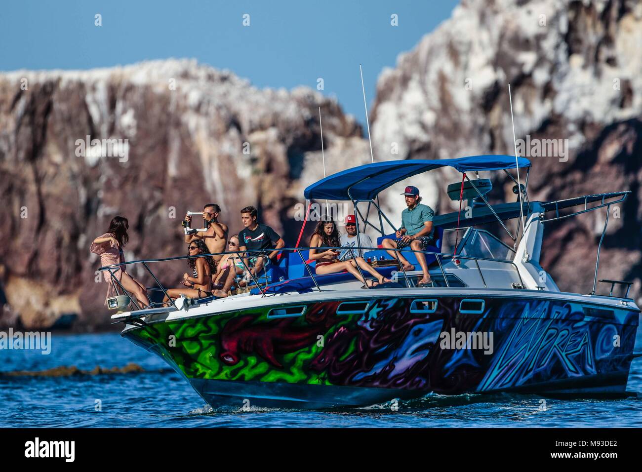 Teenage vacationers enjoy a sunny day, ride a yacht through the bay and ...