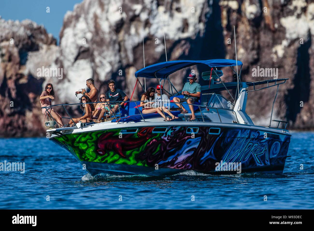 Teenage vacationers enjoy a sunny day, ride a yacht through the bay and ...