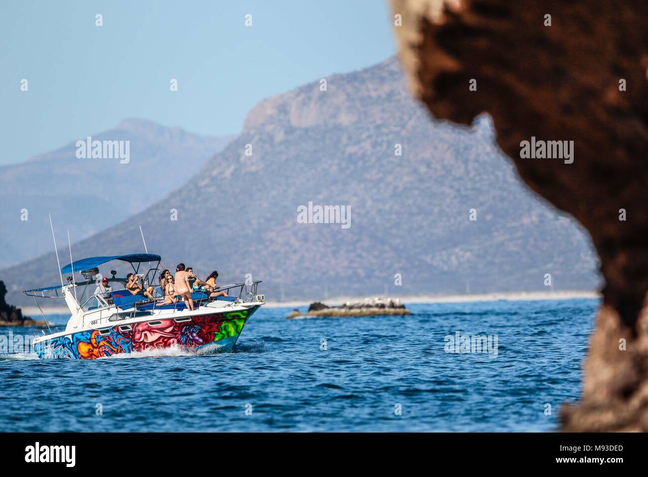 Teenage vacationers enjoy a sunny day, ride a yacht through the bay and ...