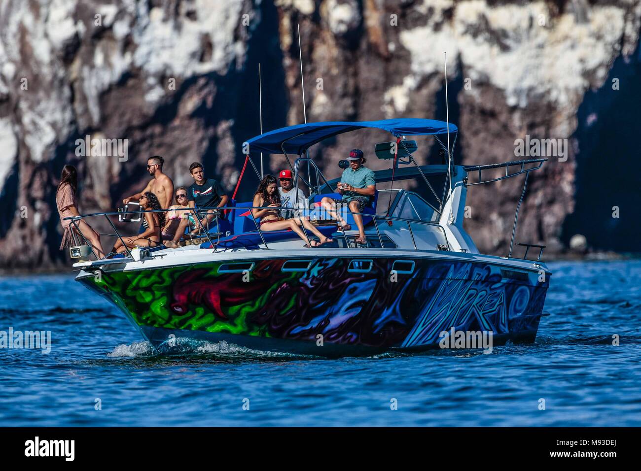 Teenage vacationers enjoy a sunny day, ride a yacht through the bay and ...