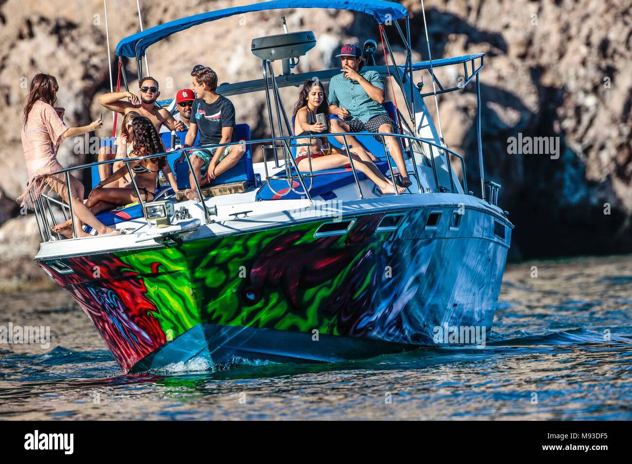 Teenage vacationers enjoy a sunny day, ride a yacht through the bay and ...