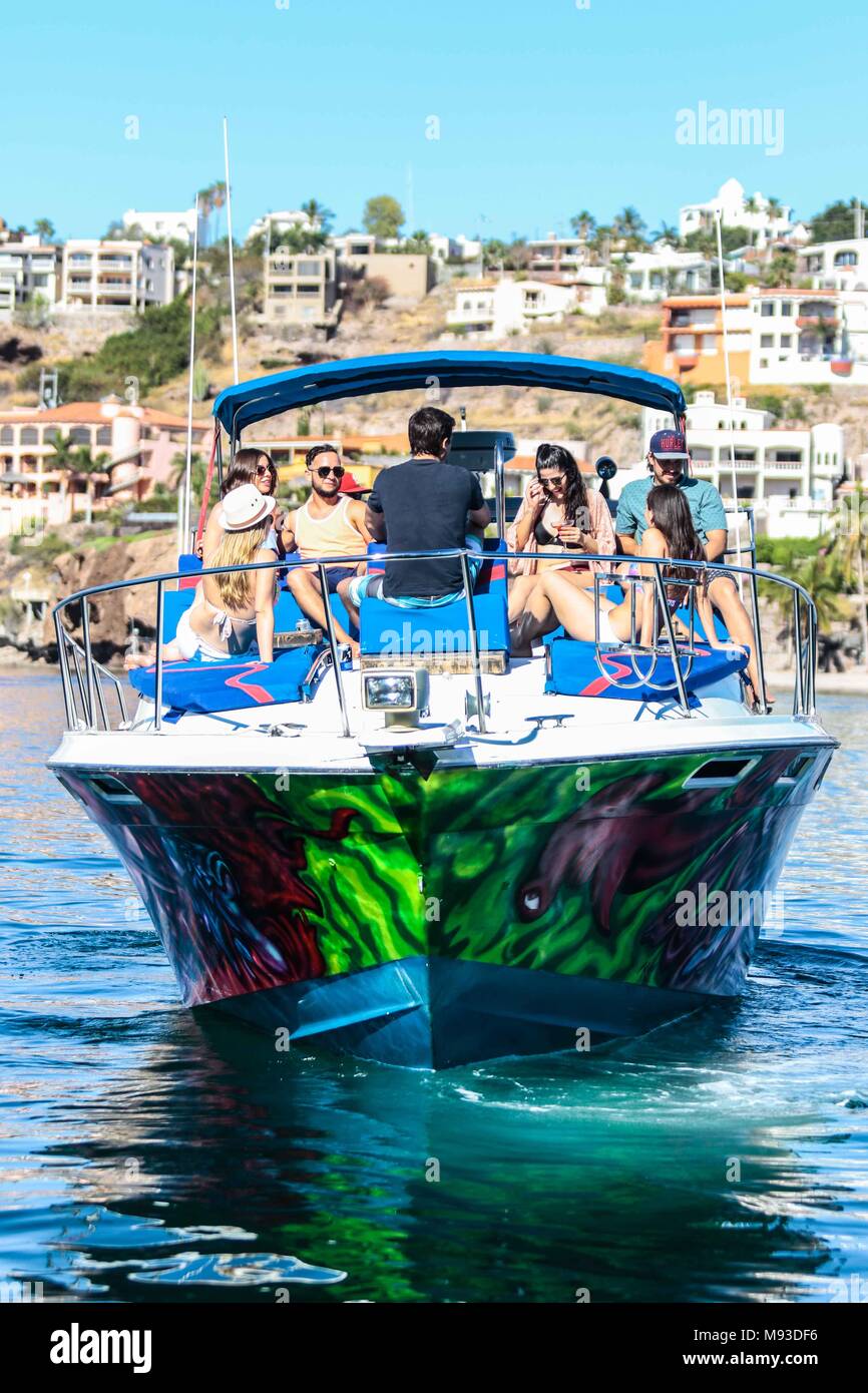 Teenage vacationers enjoy a sunny day, ride a yacht through the bay and ...