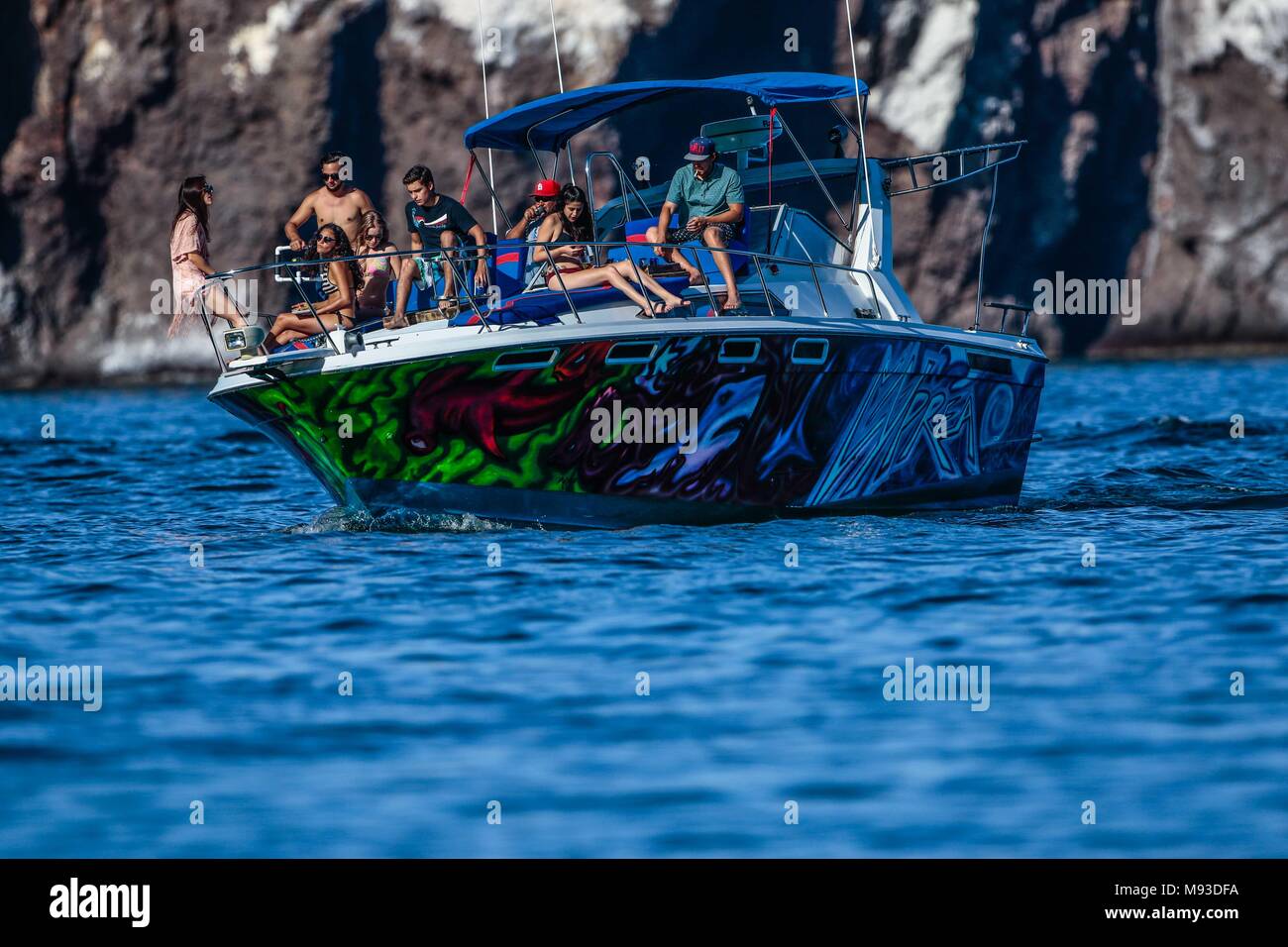 Teenage vacationers enjoy a sunny day, ride a yacht through the bay and ...