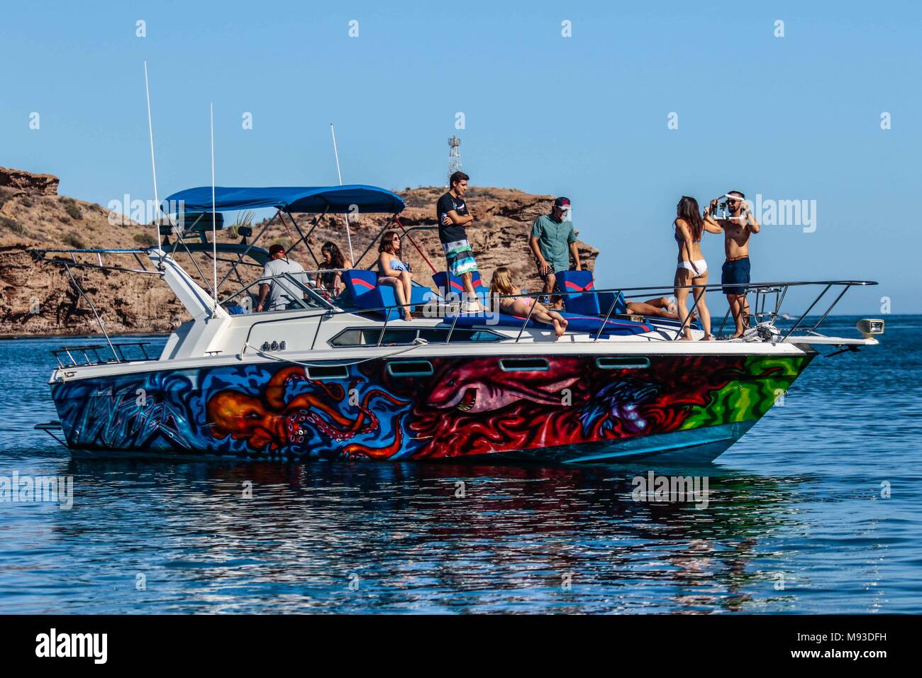 Teenage vacationers enjoy a sunny day, ride a yacht through the bay and ...