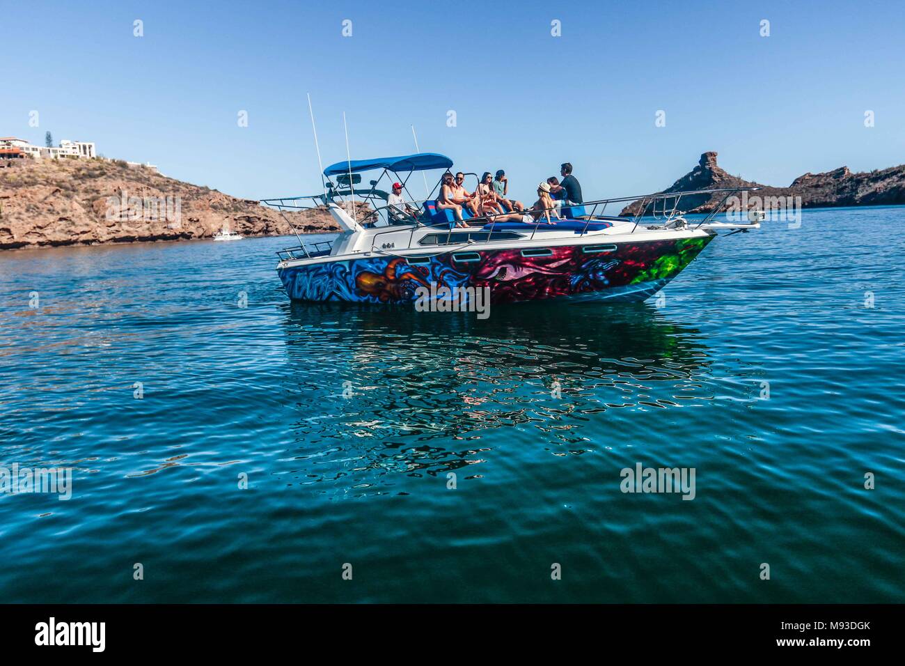 Teenage vacationers enjoy a sunny day, ride a yacht through the bay and ...