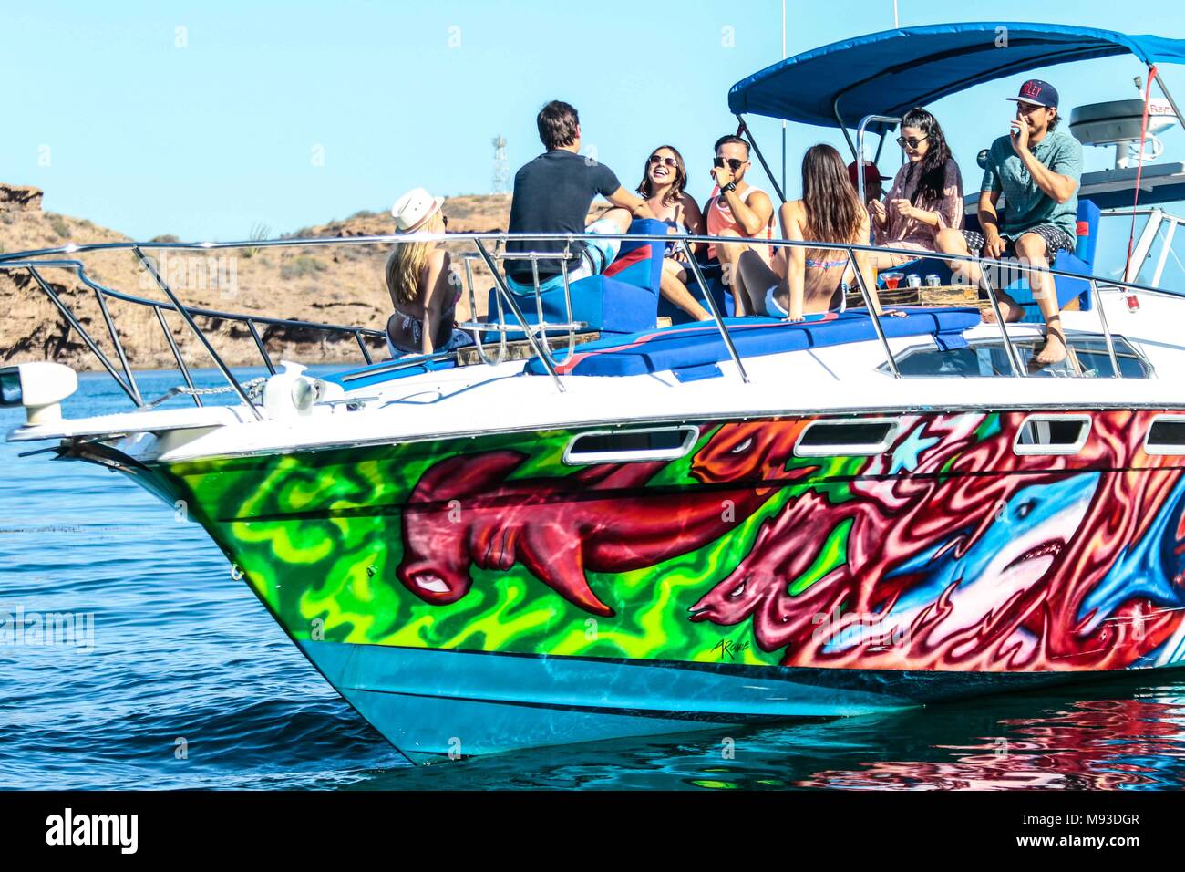 Teenage vacationers enjoy a sunny day, ride a yacht through the bay and ...