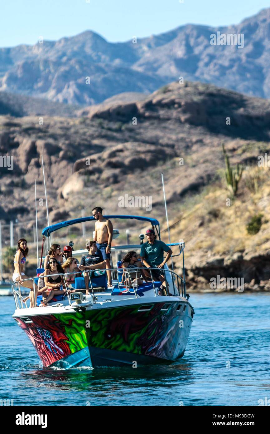 Teenage vacationers enjoy a sunny day, ride a yacht through the bay and ...