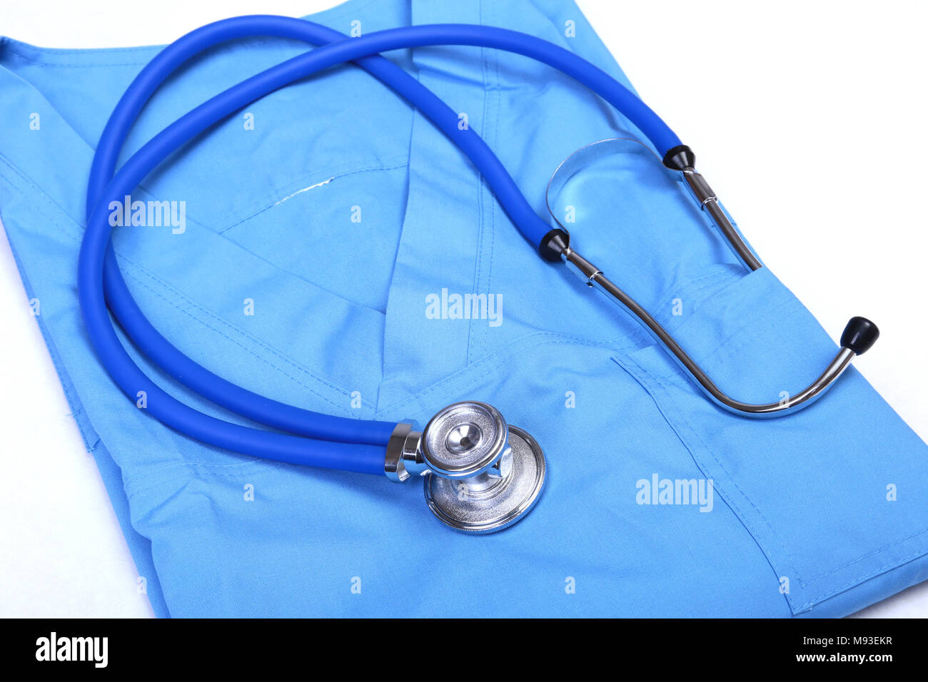 Medical stethoscope head lying on blue doctor uniform closeup. Medical ...