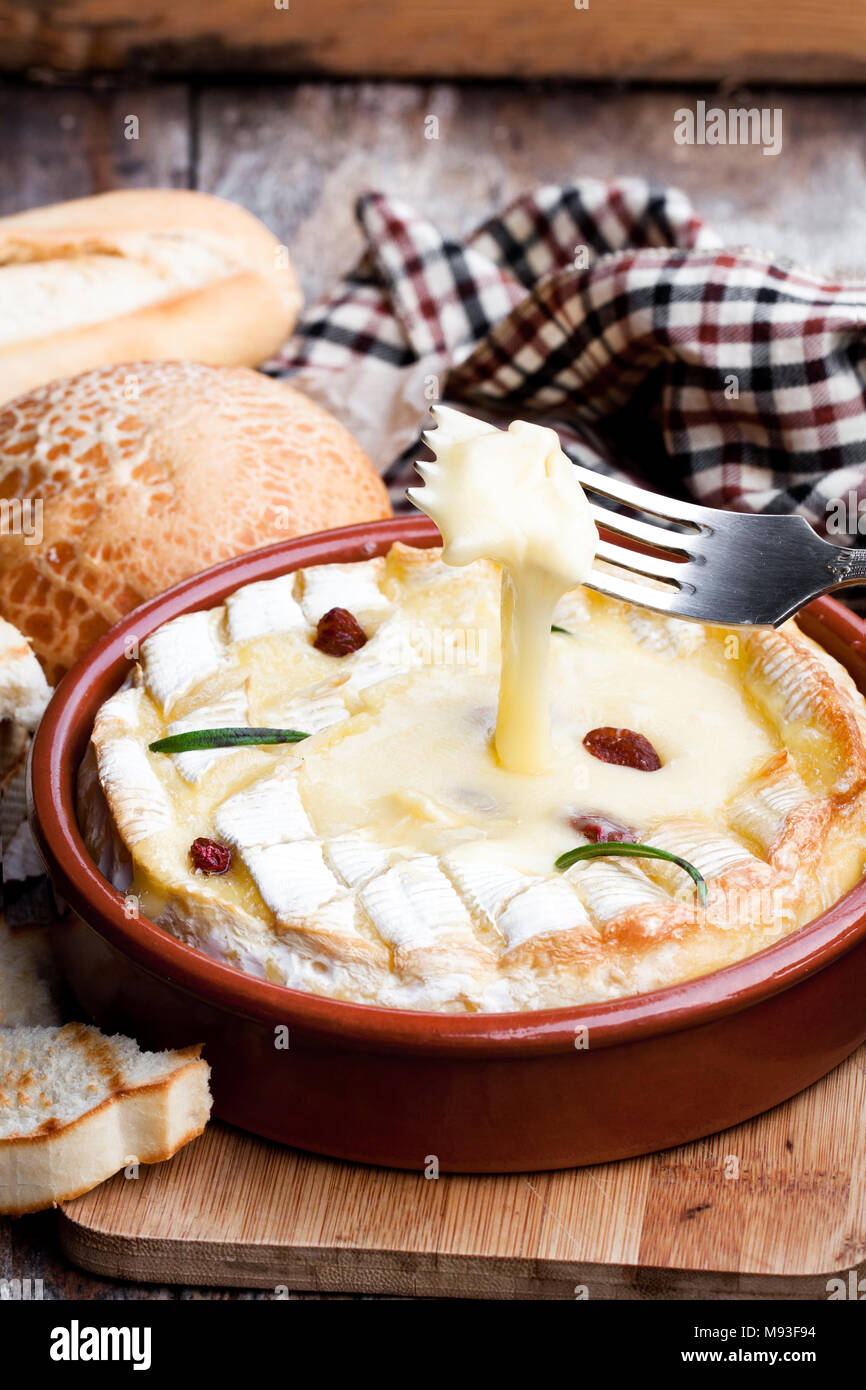 Delicious hot baked camembert with sultanas on wooden table Stock Photo ...