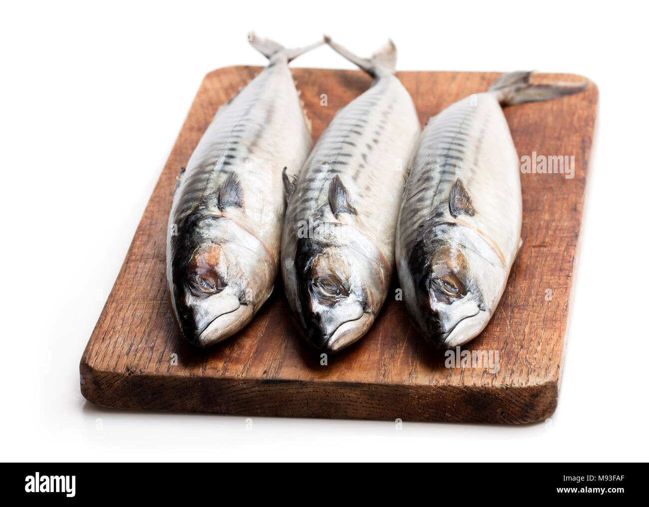 Tree raw whole mackerel on wooden board isolated on white Stock Photo ...