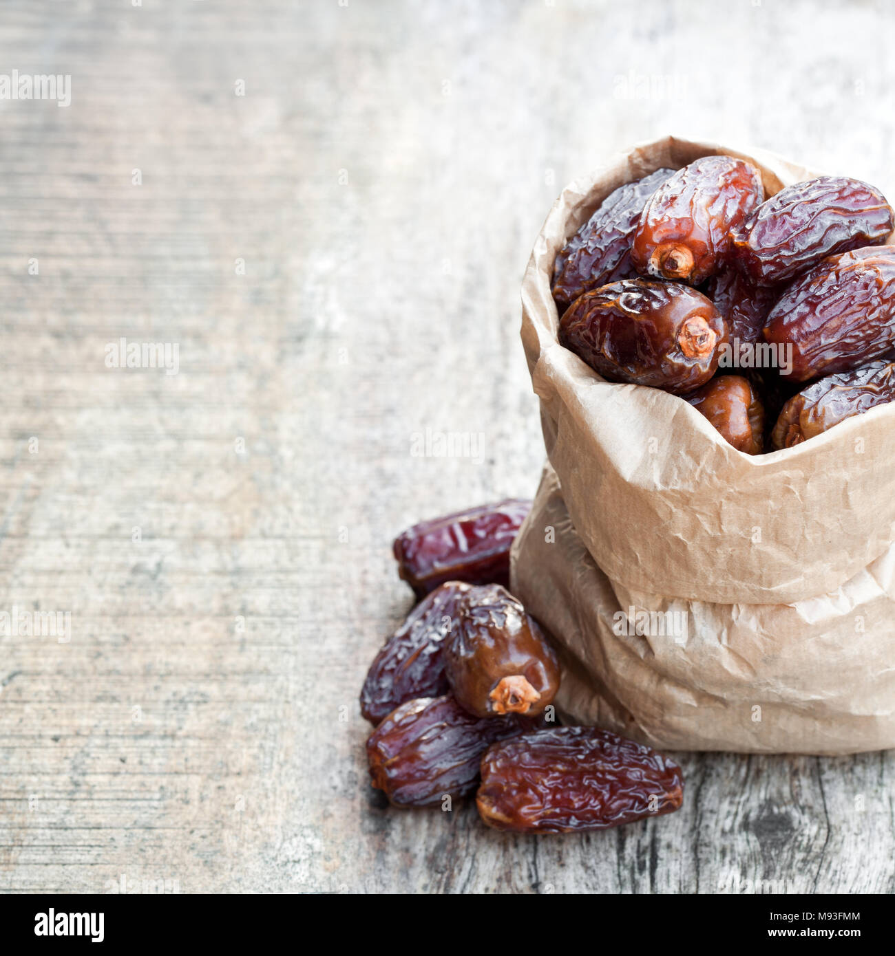 Dried dates in paper bag on wooden table Stock Photo - Alamy