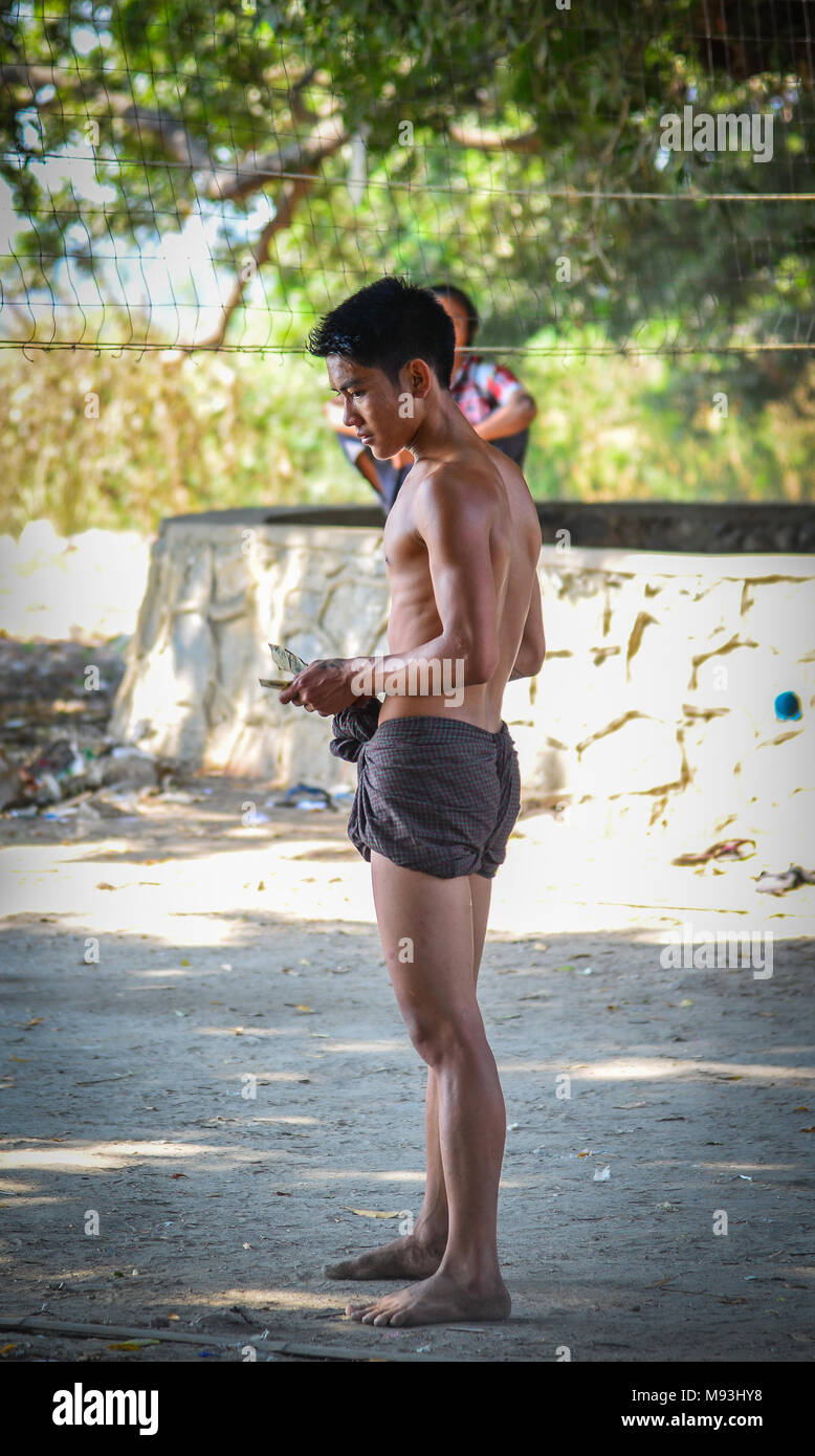 Mandalay, Myanmar - Feb 11, 2017. A Burmese man with longyi standing at the village in Mandalay ...
